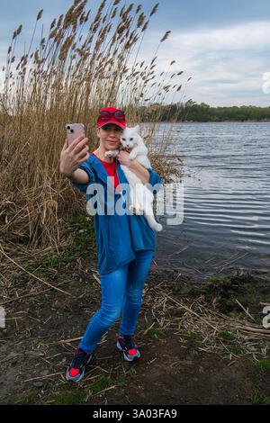 Girl walking with curious cat on her shoulder in the city park in ...