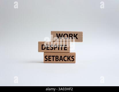 Work despite setbacks symbol. Wooden blocks with words Work despite ...