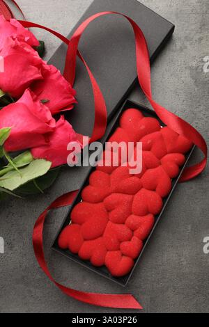 Chocolate bar decorated with hearts in box on grey table, top view ...