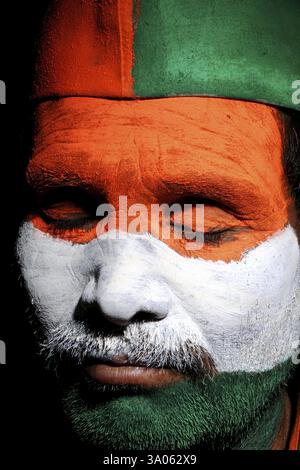 man with tricolour painted on his face smiling with enthusiasm ...