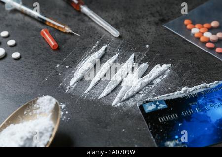 Drug addiction. Powder, syringes and credit card on gray textured table ...