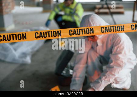 Caution police tape. Detectives are collecting evidence in a crime ...