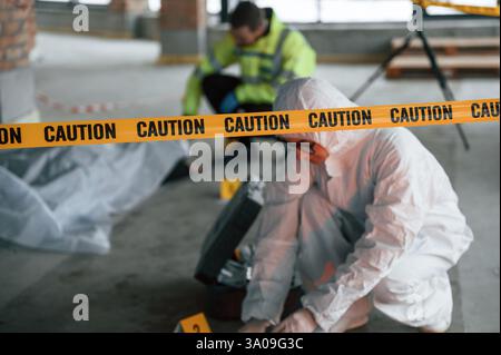 Caution police tape. Detectives are collecting evidence in a crime ...