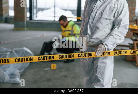 Holding caution police tape. Detectives are collecting evidence in a ...