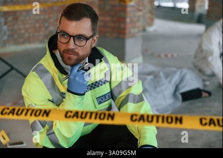 Sitting near caution police tape. Detectives are collecting evidence in ...