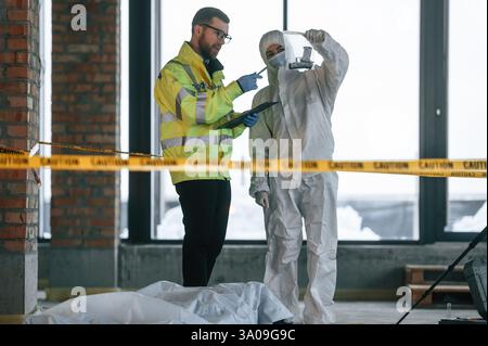 At daytime. Detectives are collecting evidence in a crime scene near ...