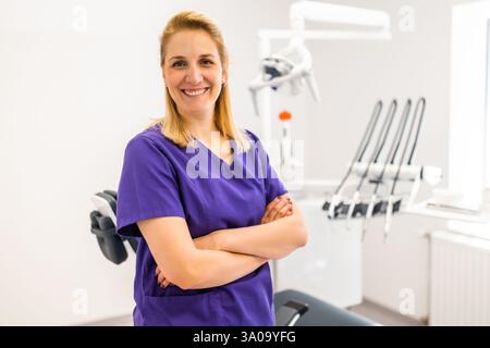 Confident female dentist in dental office with male patient in chair ...