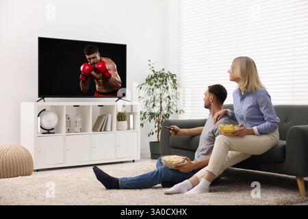 Couple watching boxing fight on TV set at home Stock Photo - Alamy