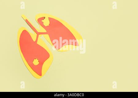 Paper lungs with burnt holes on green background. Lung cancer concept ...