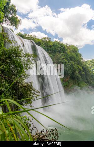 The waterfall interrupts violently the peaceful continuous flow of the ...