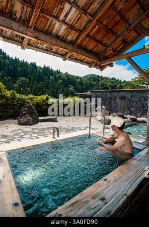 Visitors enjoy the rotenburo outdoor bath at Seifuso in Odate City ...