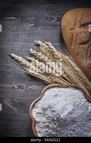 Ripe wheat rye ears wooden spoon flour raw spiral macaroni on black ...