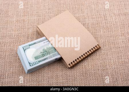 Banknote bundle of US dollar placed on a notebook Stock Photo - Alamy