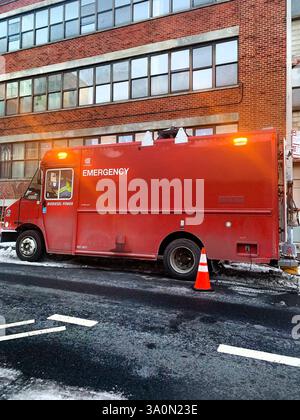 A Con Edison emergency repair red truck at a utility manhole in the ...