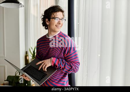 Non binary person studying using computer laptop sitting on the floor ...