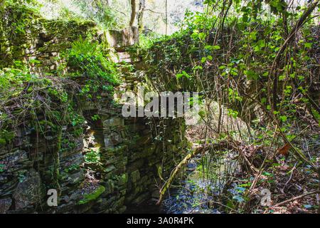 An old flagstone bridge over a small river on the hill in Portugal ...