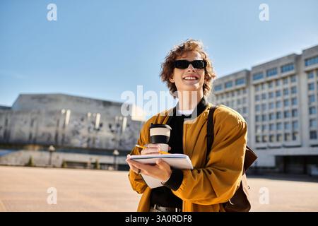 Handsome man holds a notebook and coffee, surrounded by a vibrant ...