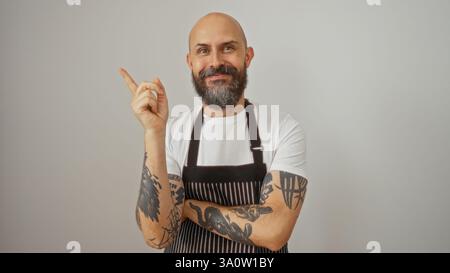 Hispanic man with tattoos standing over blue background clueless and ...