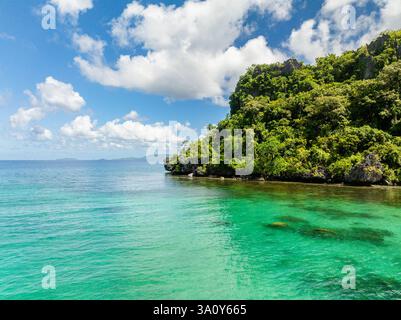 A cliff in the greenish blue sea against the background of the sky ...