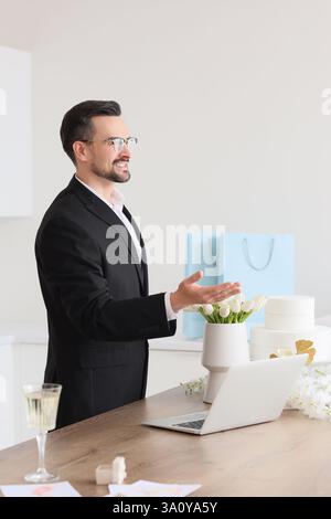 Male wedding planner working at table in office Stock Photo - Alamy