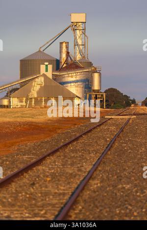 Looking along railway tracks toward a ruarl grain silo and towers at ...