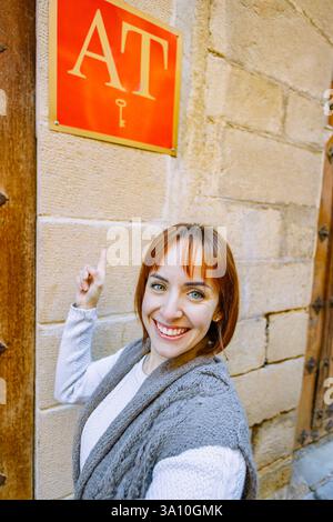 Traveler pointing at rural tourist apartment entrance in Spain ...