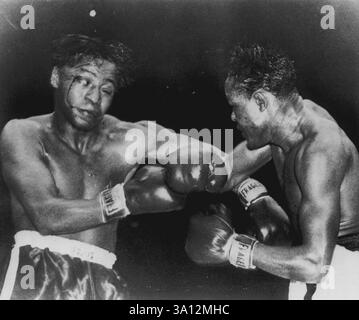 Welterweight champion Kid Gavilan, left, of Cuba pulls away from a ...