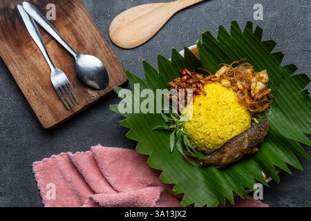 Authentic Indonesian Nasi Kuning served on banana leaves with fried ...