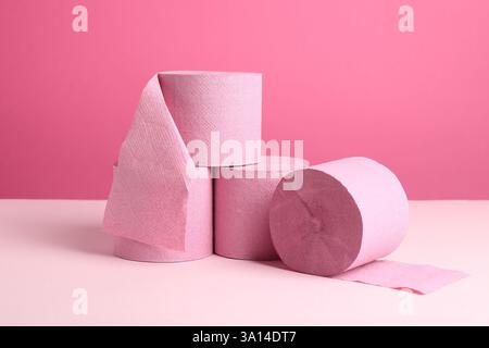 Color toilet paper rolls on pink background Stock Photo - Alamy