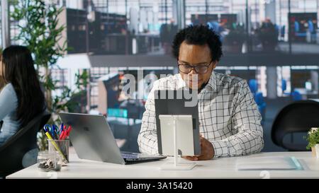Black man employee joins a telecommuting session at his office desk ...