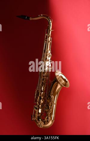 Jazz. One golden saxophone on red background Stock Photo - Alamy