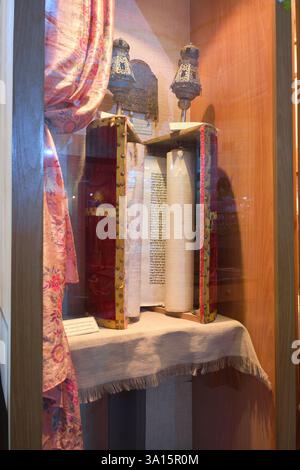 View of a holy Torah scroll in an Ark case and red velvet cover. At the ...