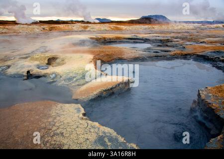 Steaming volcanic fumarole, boiling mud pit and mineral stained earth ...