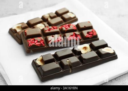 Delicious chocolate bars with different flavors on light table, flat ...