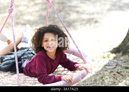 Child lying on a swing at outdoor playground in spring Stock Photo - Alamy