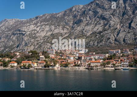 View of the small town of Dobrota with a backdrop of mountains in Kotor ...