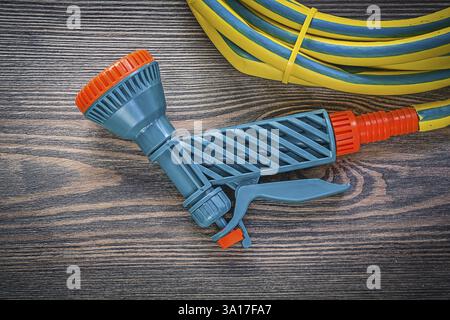 Garden hose coil water hand spray gun on wooden board agriculture ...