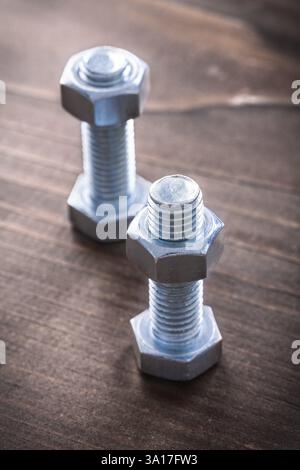 Pair of stainless nuts and bolts on metallic background construction ...