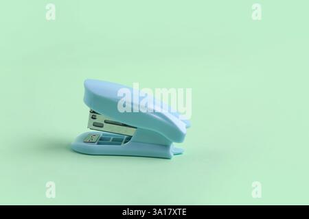Blue stapler on green background Stock Photo - Alamy