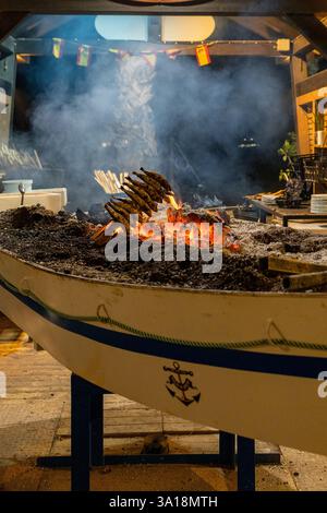 Grilled fish on skewers over open fire, outdoor cooking, barbecue ...