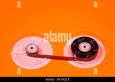 Magnetic tape on reels from the inside of a VHS videocassette on white ...