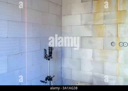 Laser level on the block wall. A builder makes arrangements with a ...
