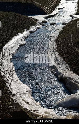 frozen fast flowing spring water, icy rocks and water stream, frosty ...