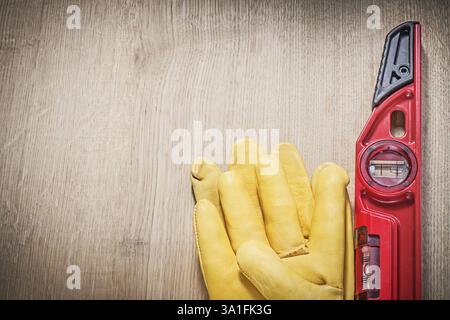 Leather protective gloves red construction level on wooden board Stock ...