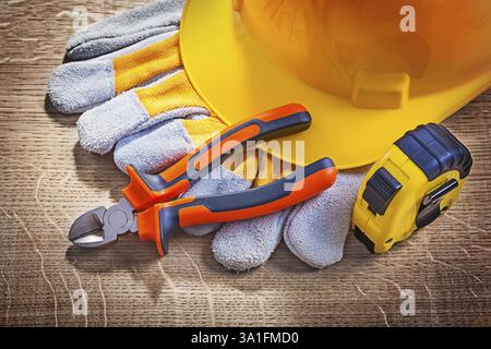 Nippers safety gloves hard hat tape measure on wooden board Stock Photo ...