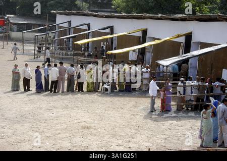 People stand in queue to cast their votes at a polling center during ...