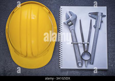 Adjustable wrench notebook on black background construction concept ...