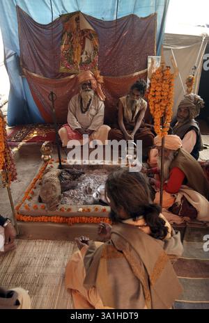 Naga sadhus from the Juna Akadha sits with his Trishul at their camp ...