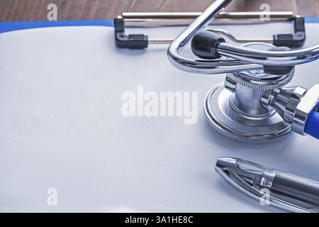 stethoscope clipboard ballpoint pen on vintage wooden board wery close ...