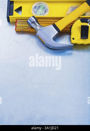 Construction level Measuring tape and claw hammer on metallic ...